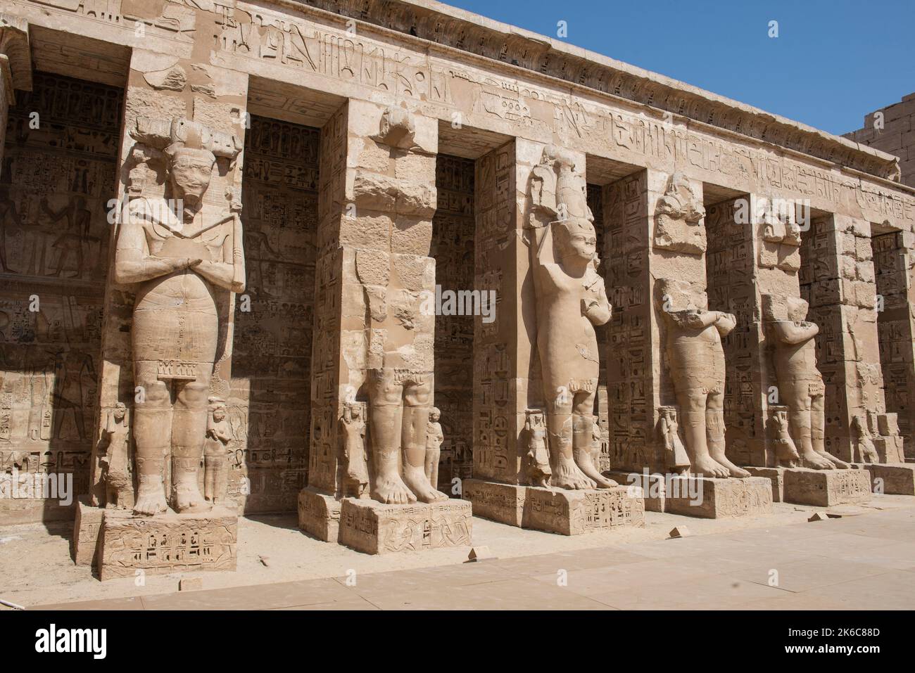 Large statues of Ramses II in ancient egyptian Medinat Habu Temple with ...