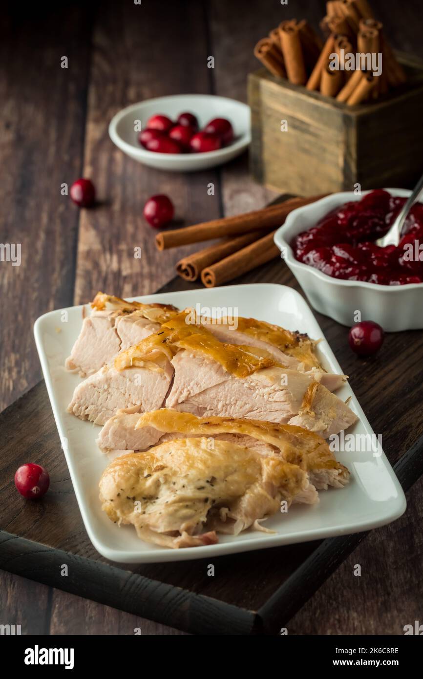 Slices of turkey on a platter with fresh homemade cranberry sauce in ...