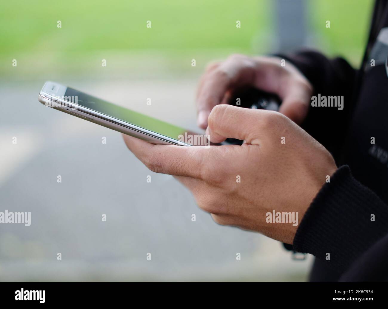 Hand holding handphone - people play handphone with blur background ...
