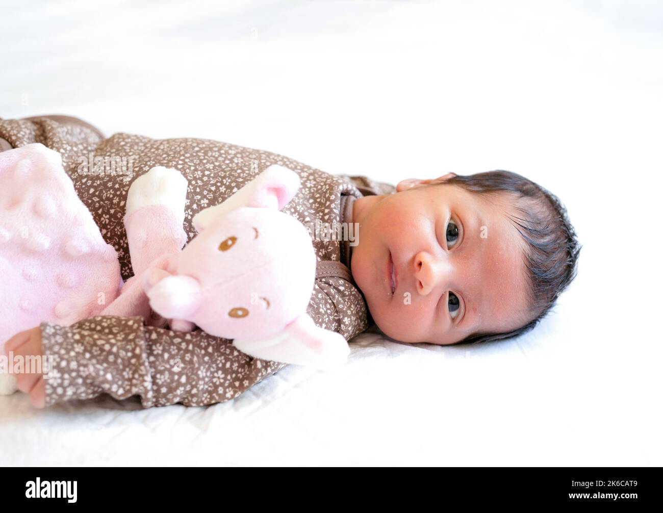 Newborn baby girl sleep first days of life. Cute little newborn child lying on bed peacefully ...
