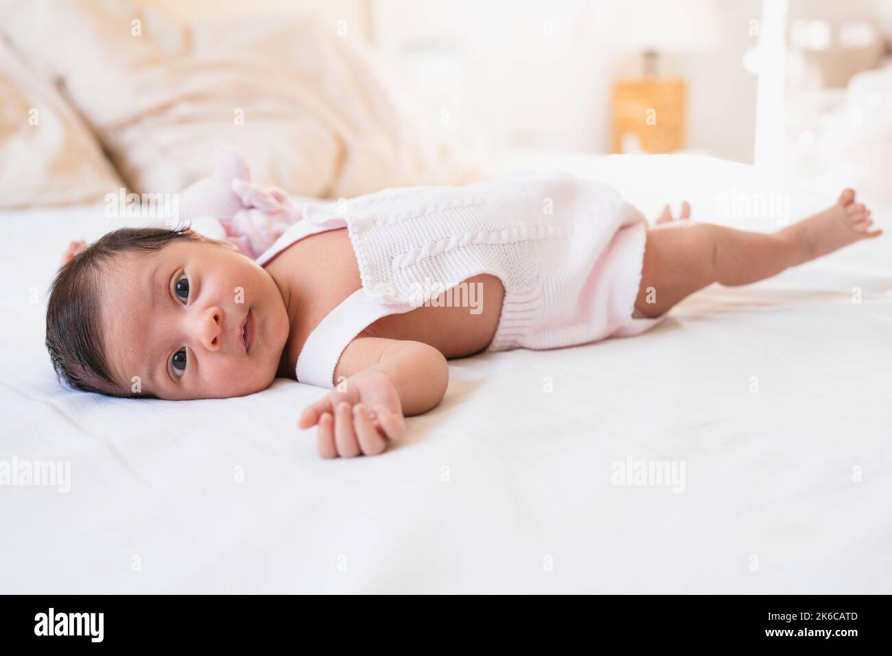 Newborn baby girl sleep first days of life. Cute little newborn child lying on bed peacefully ...