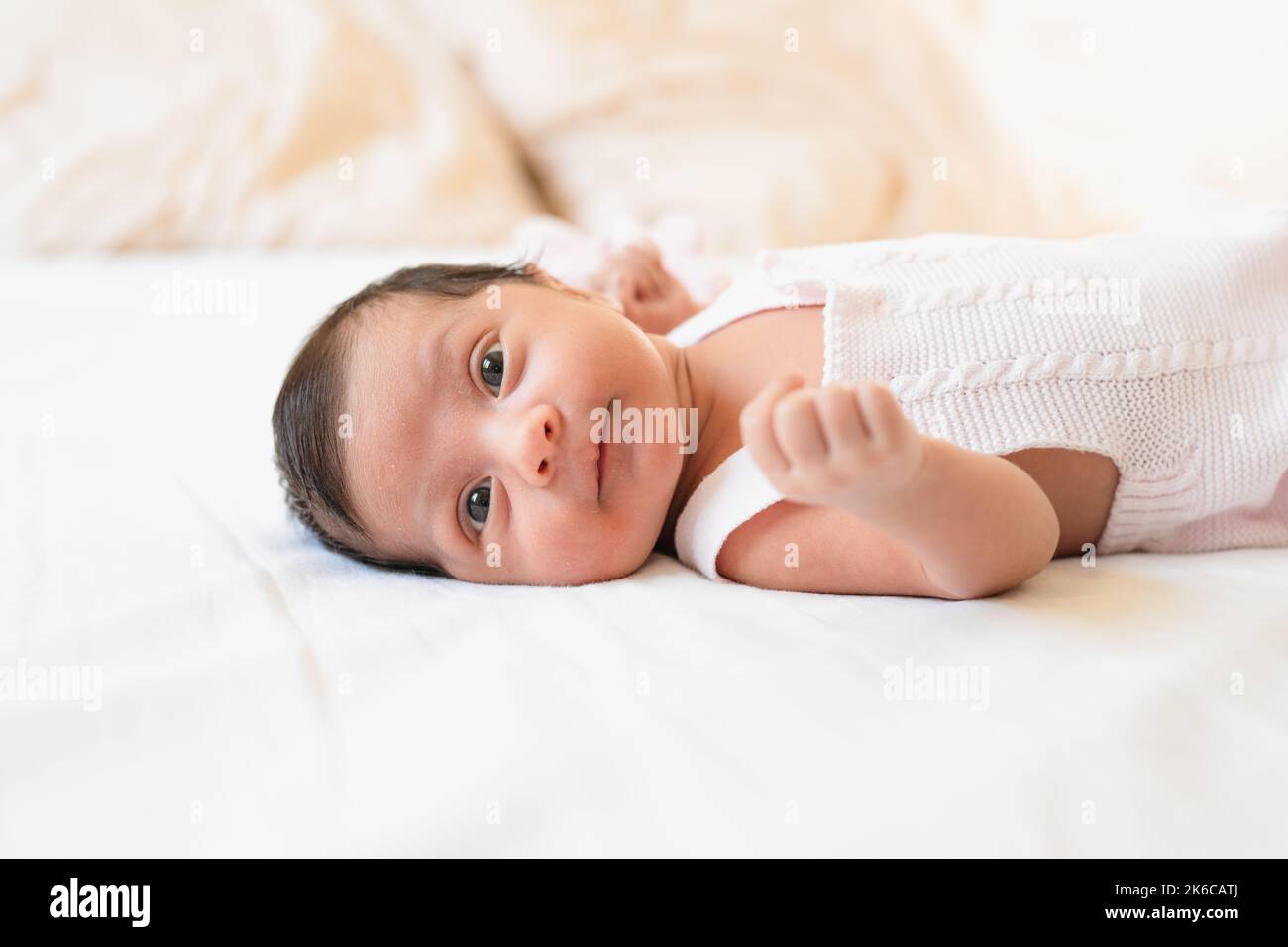 close up Newborn baby girl sleep first days of life. Cute little newborn child lying on bed ...