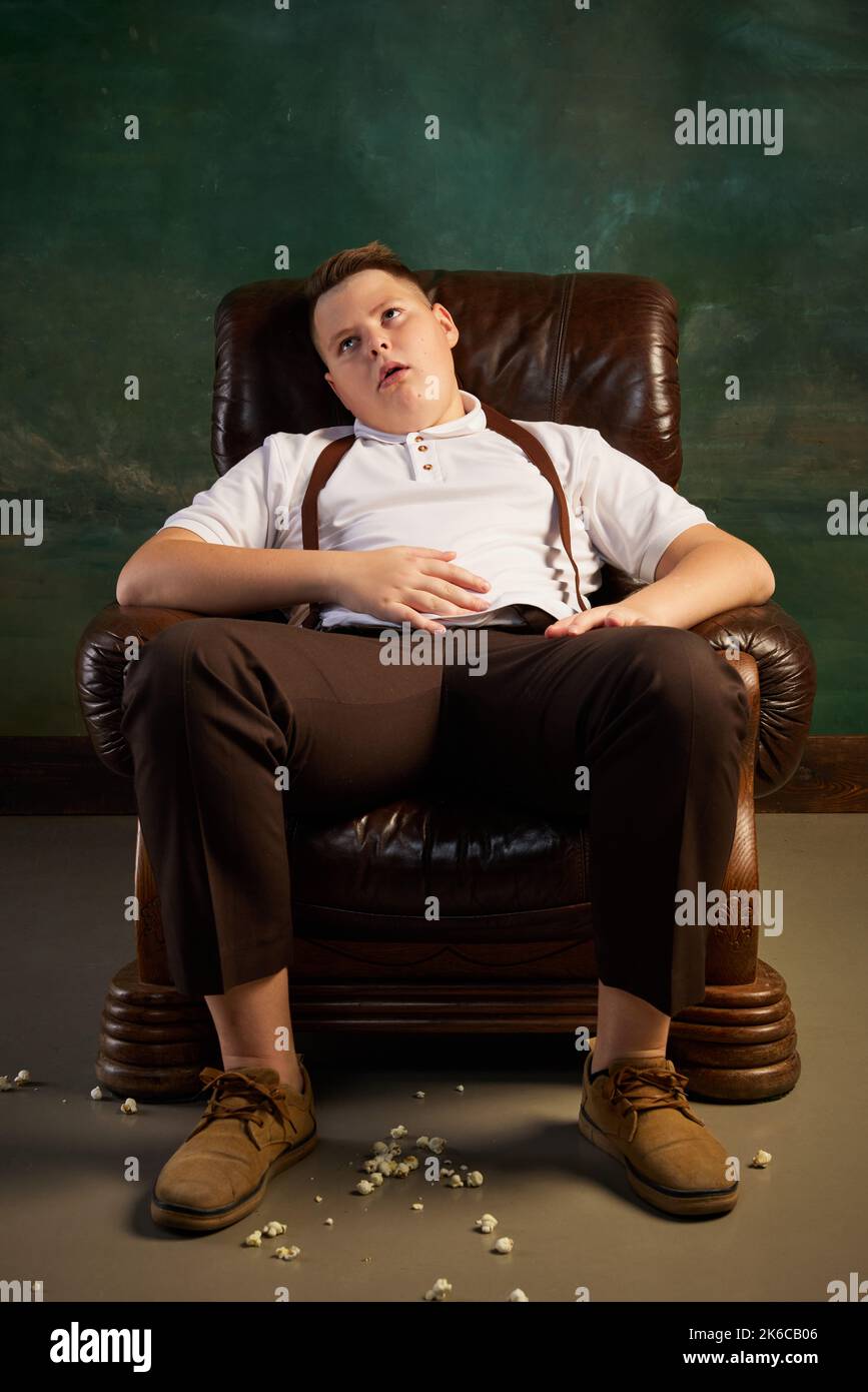 Gluttony and greed. Overweight teen boy wearing retro style clothes ...