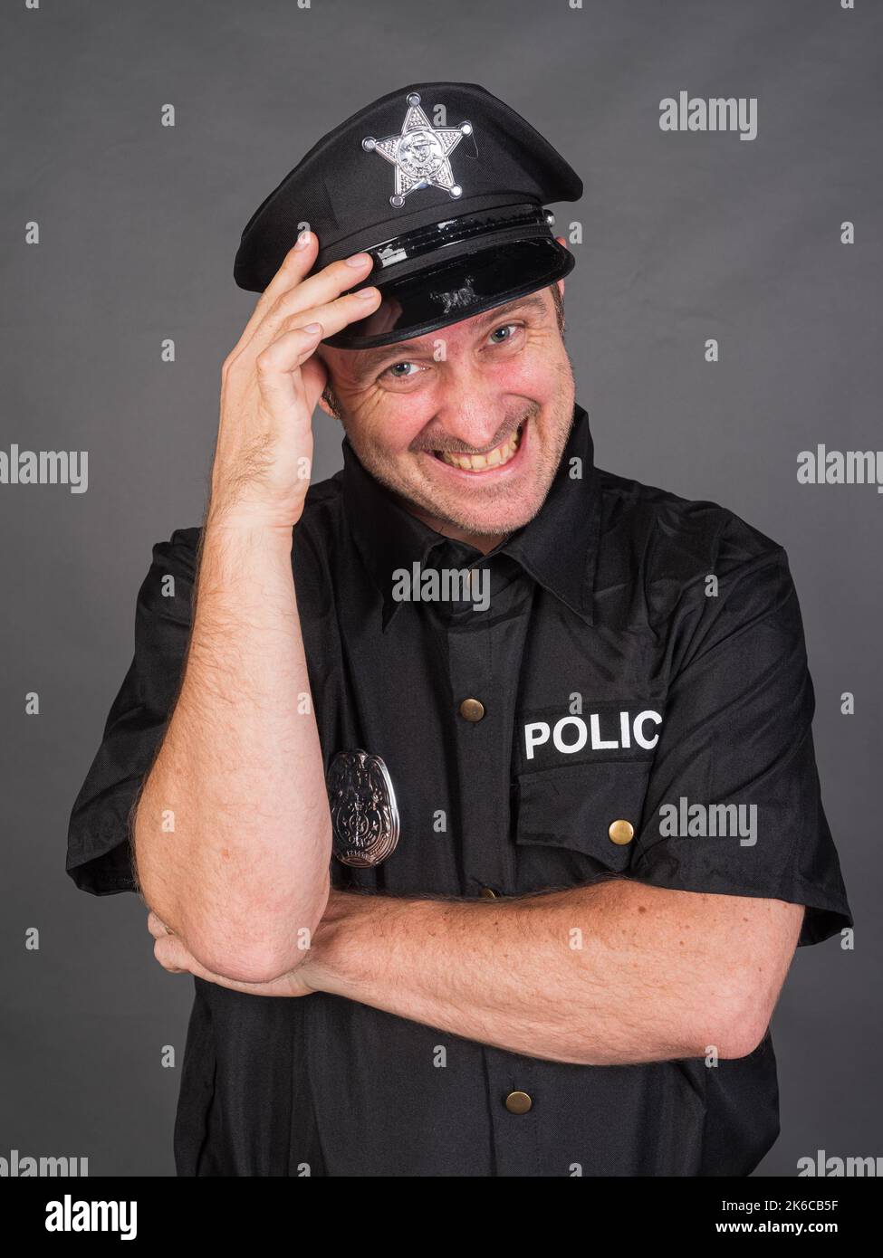 Portrait of Caucasian man wearing police uniform costume against gray ...