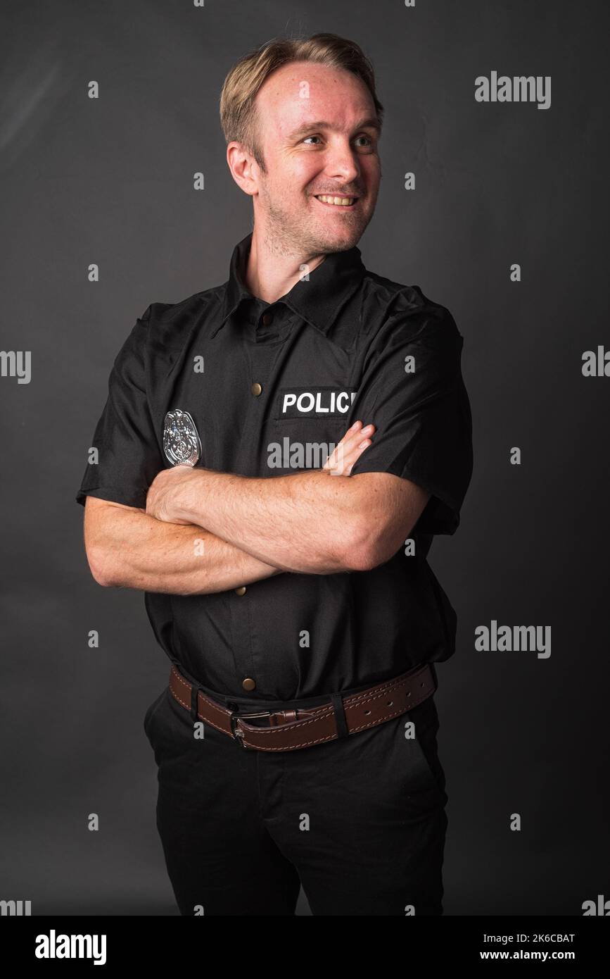 Portrait of Caucasian man wearing police uniform costume against gray ...
