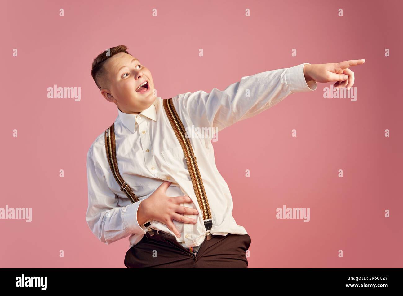 Excited big obese teen boy in white shirt and shorts with suspenders ...