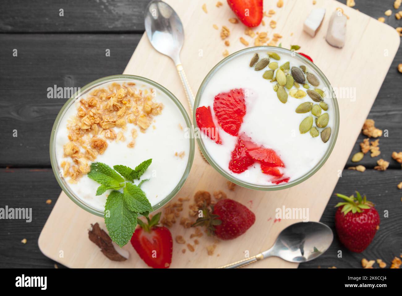 Oatmeal with yogurt and berries on a black wooden background. Top view ...