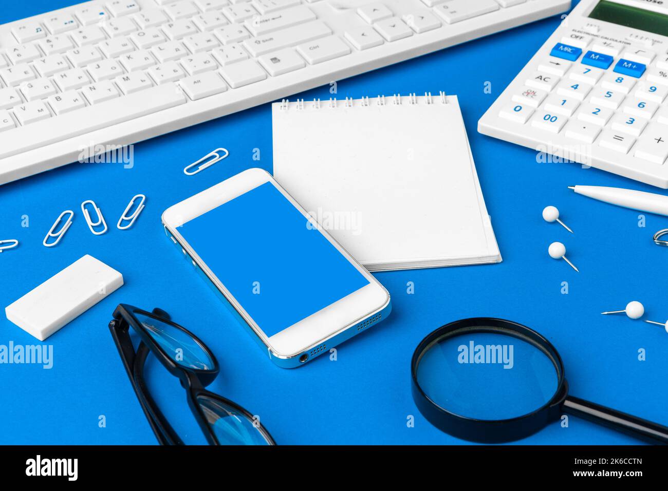 Flat lay, top view of blue office table desk. Workspace with blank note ...