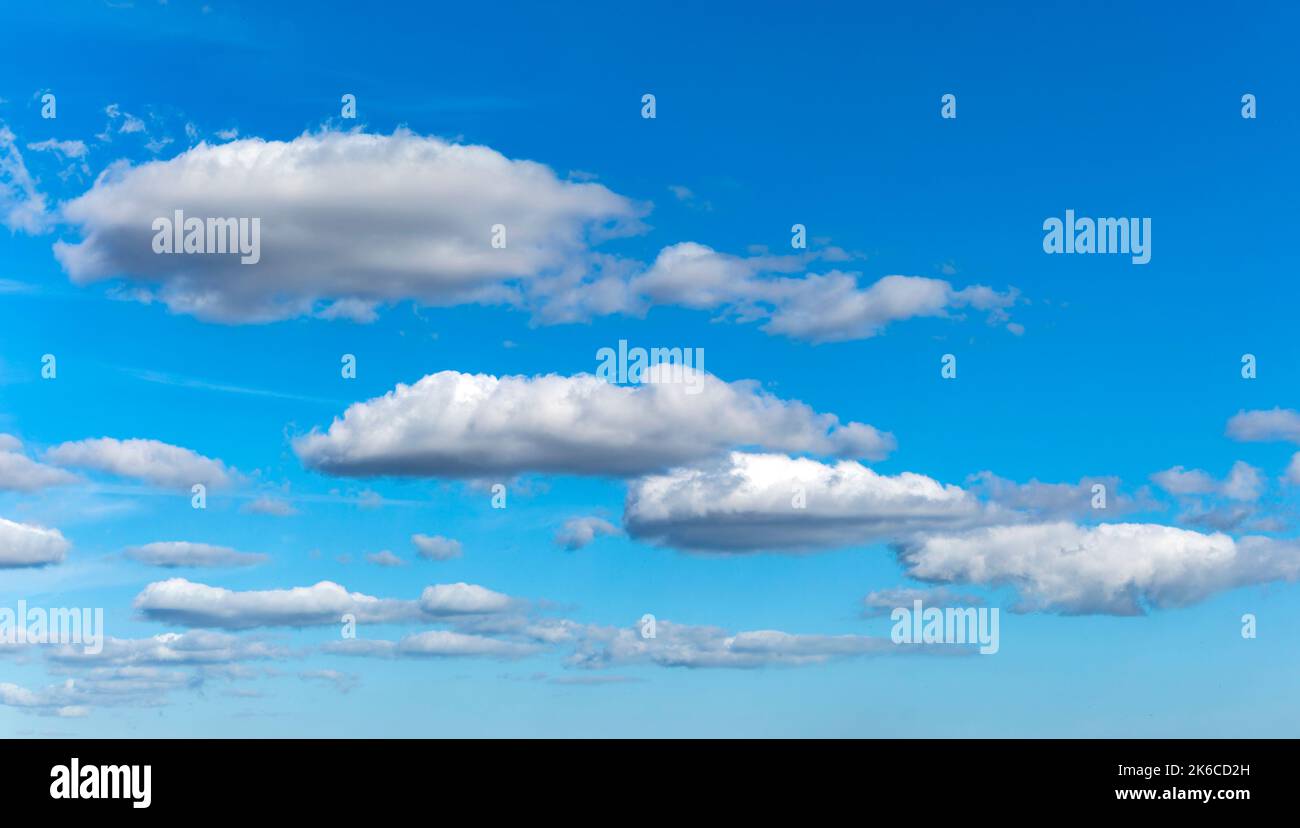 Layers of white fluffy cumulus clouds in blue sky, Suffolk, England, UK ...