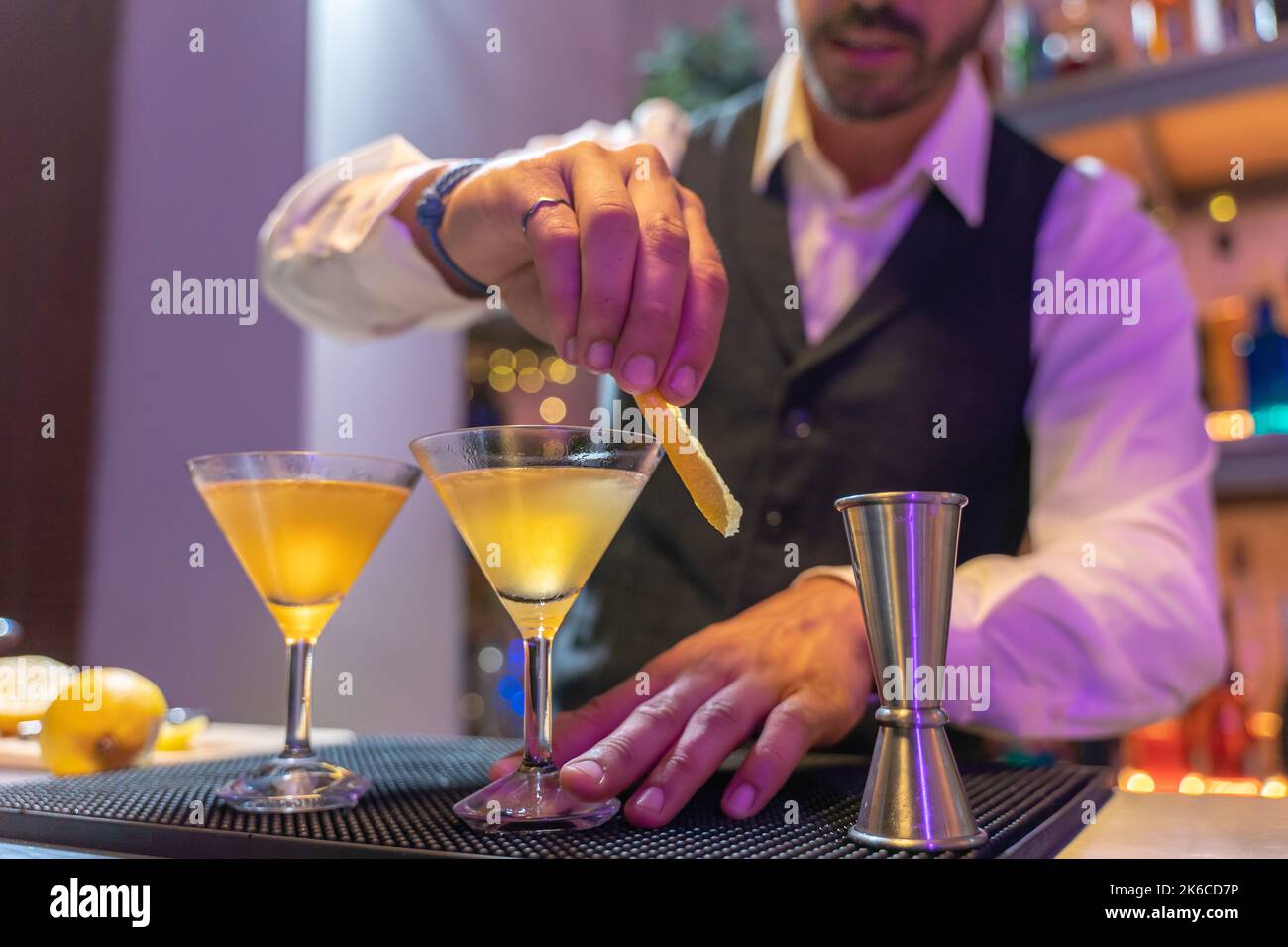 Handsome barman making elegant cocktail in night club on bar counter ...