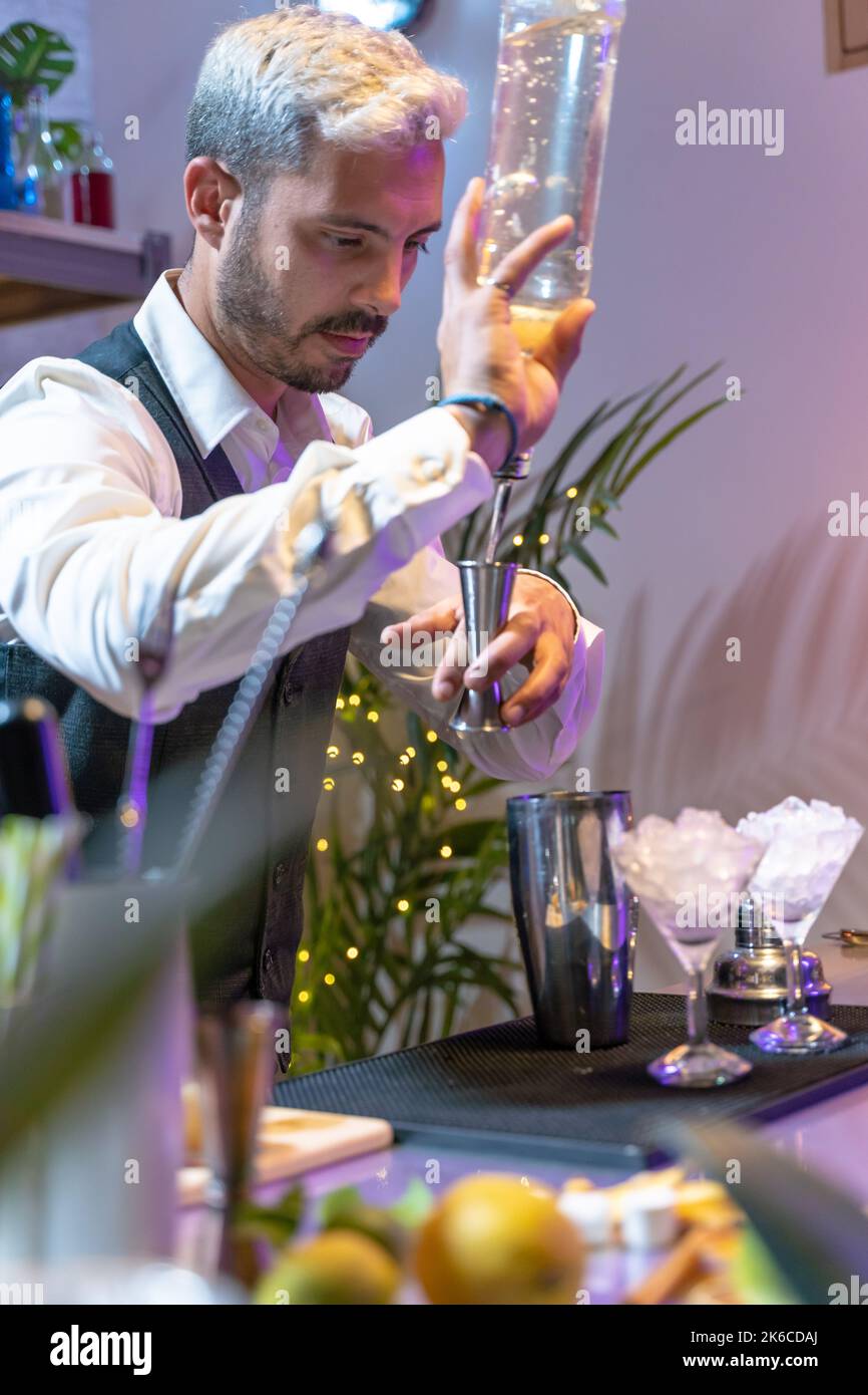 Barman making cocktail Mojito in night club adding ingredients and ...