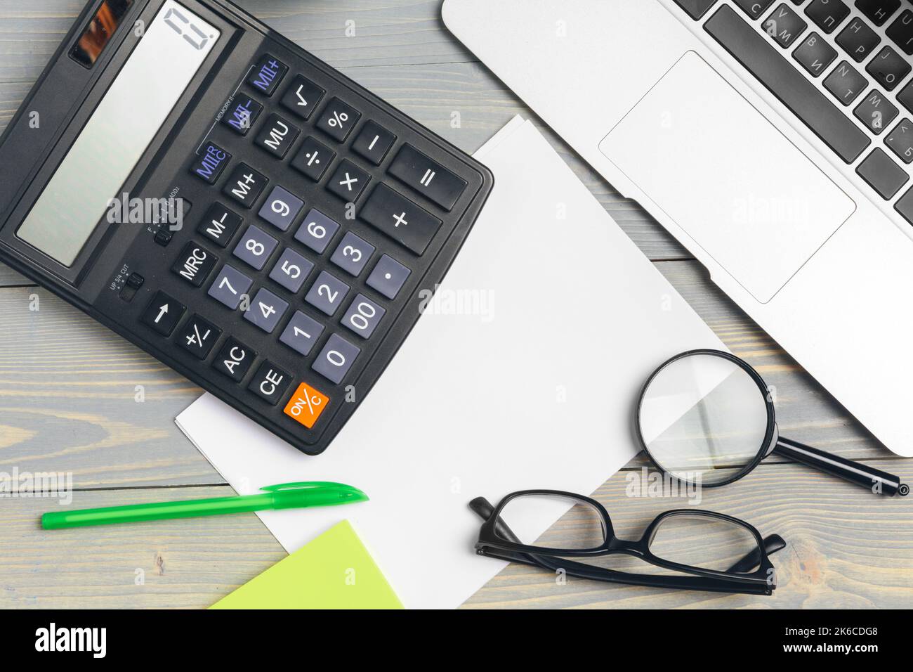 Angled View of laptop Computer Keyboard and glasses with Various Office ...