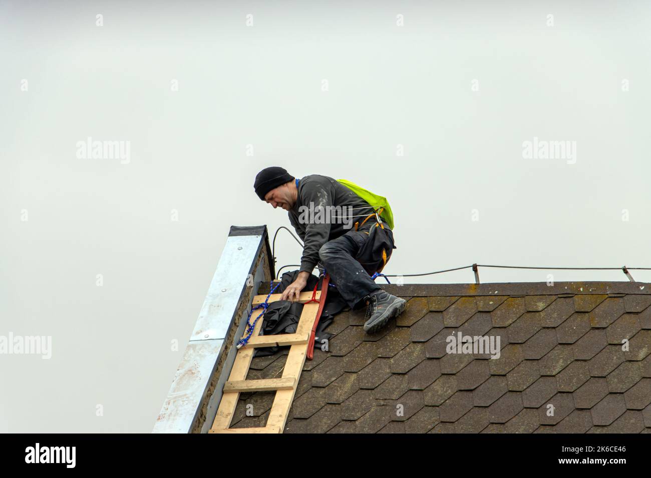 Repairman climbs a ladder while repairing the roof Stock Photo - Alamy