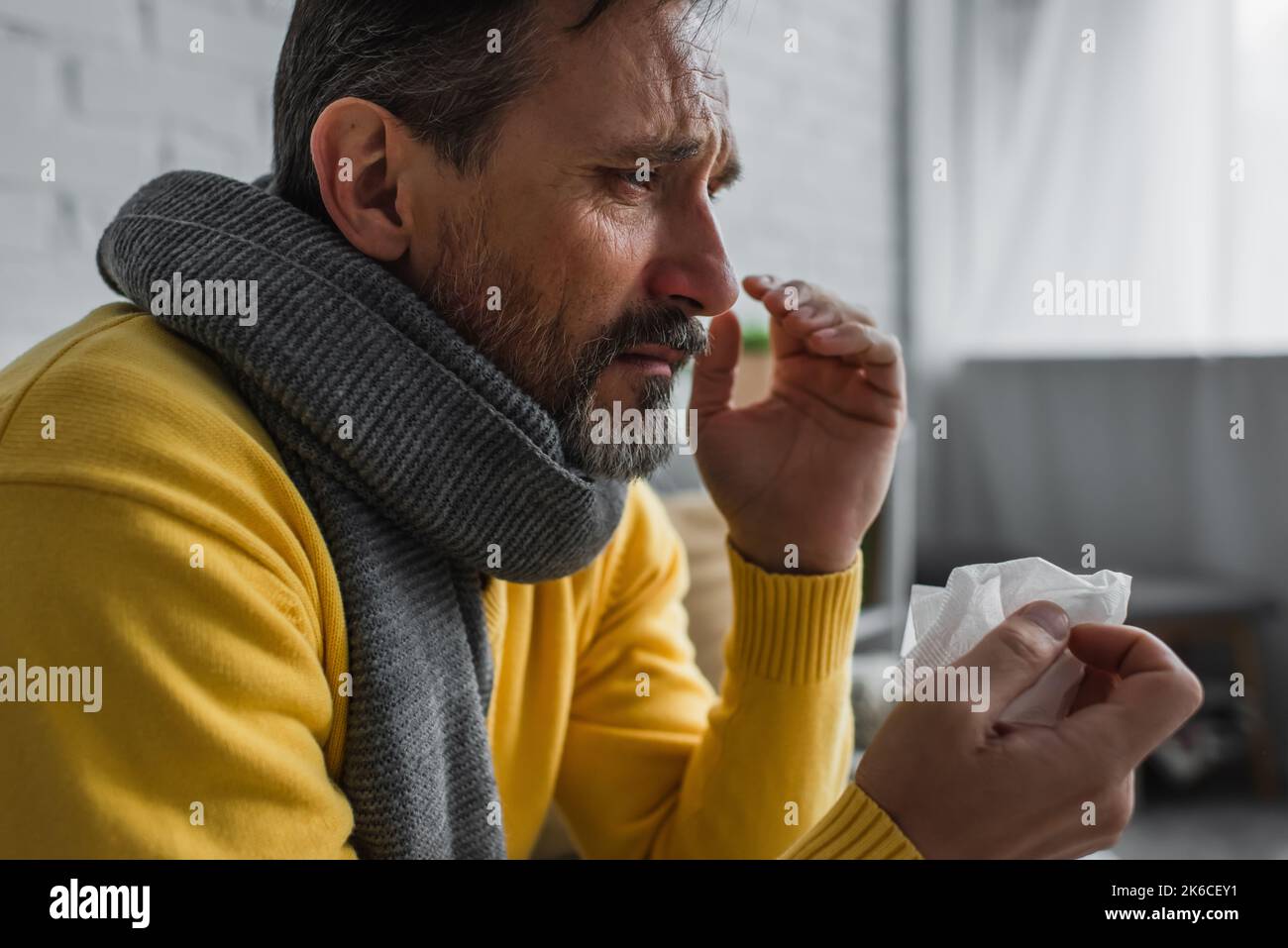 sick man with sore throat and runny nose wearing warm scarf and holding ...