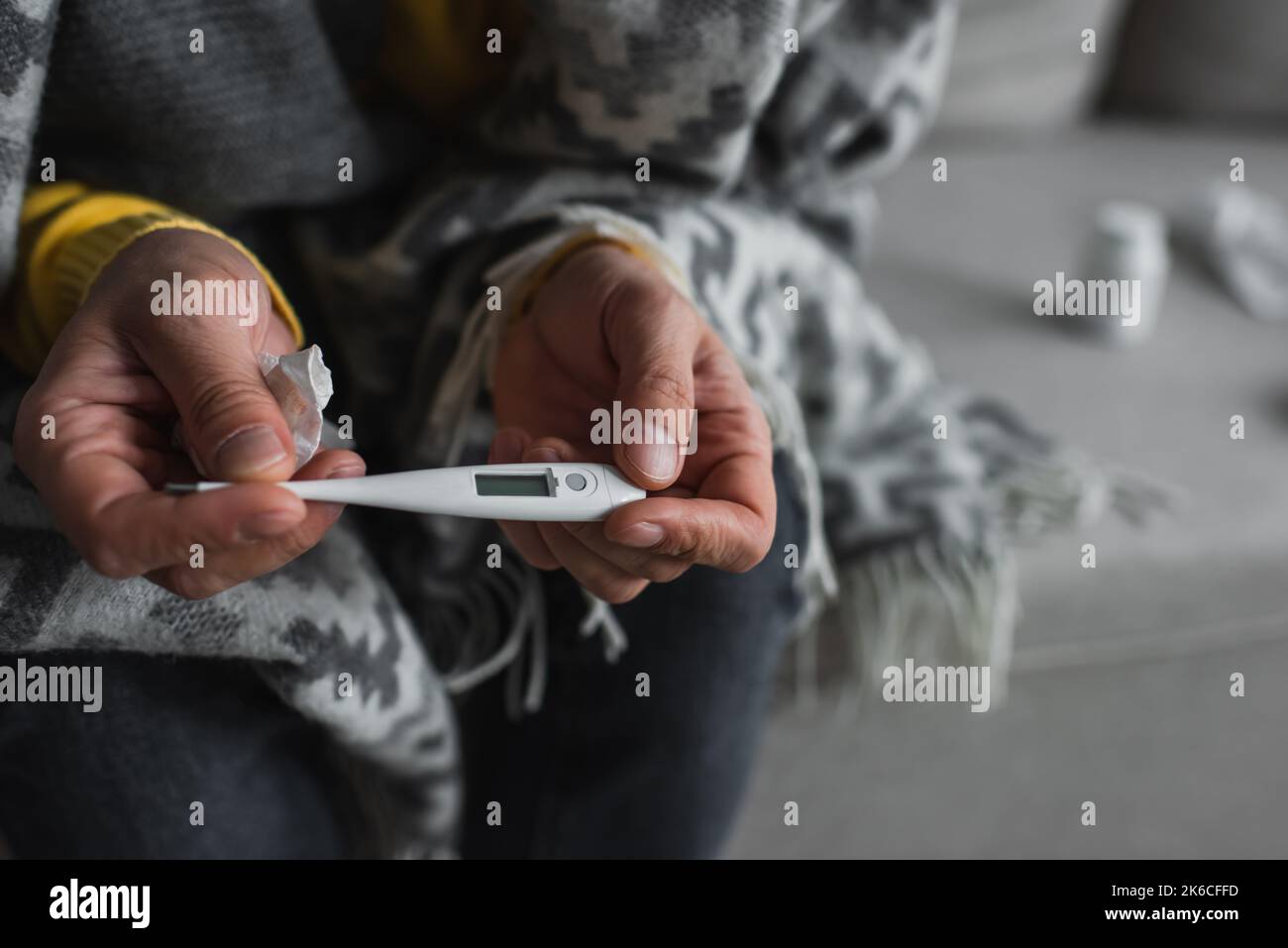 partial view of diseased man holding electronic while suffering from ...