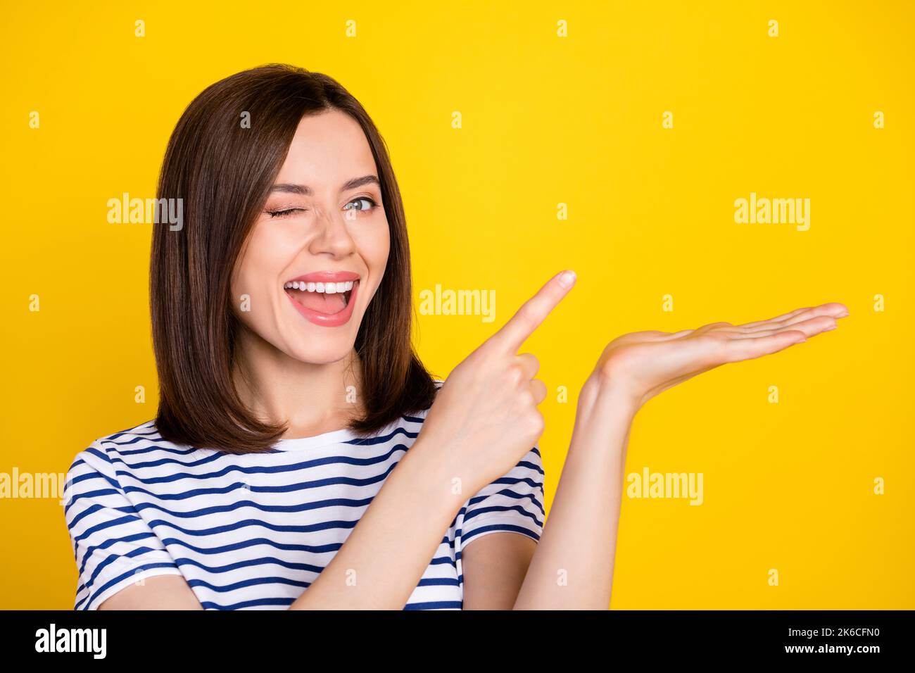 Photo of young attractive smiling cute woman blinking finger directing ...