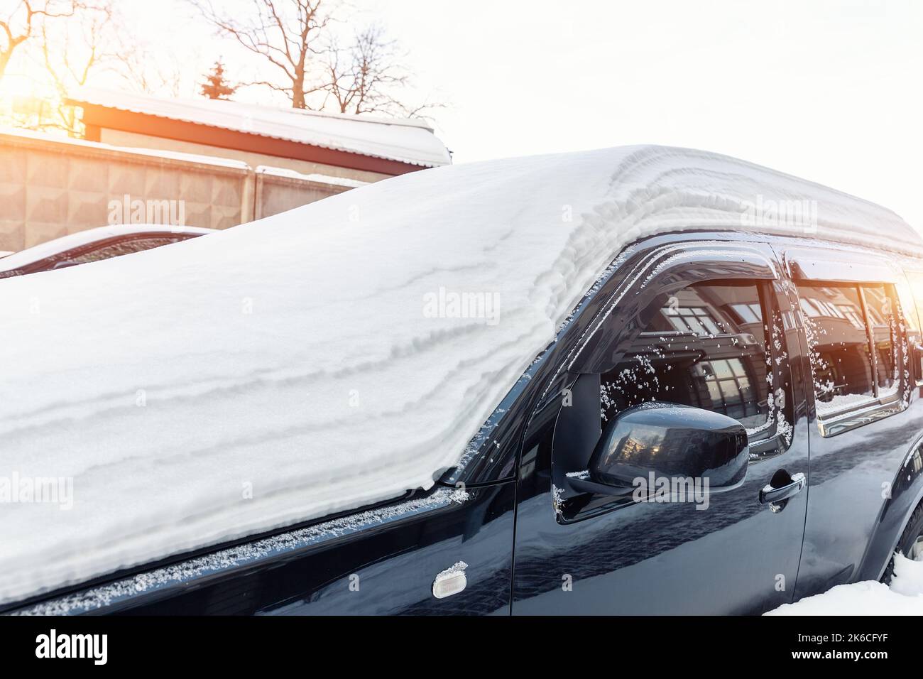 City street driveway parking lot spot with small car covered snow stuck ...
