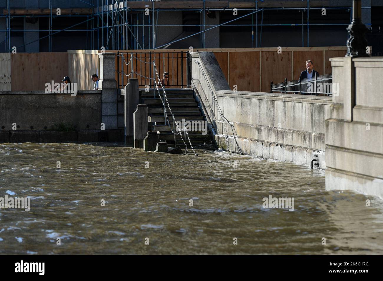 The river Thames at high tide lapping against the walls under London ...