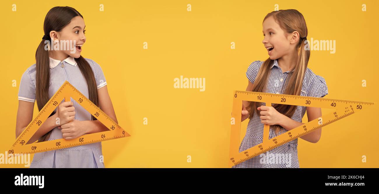 School girls friends. Happy school age children hold triangular rulers ...