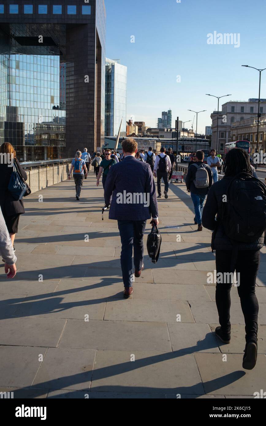 Business man with a carry bag walks across London Bridge in rush hour ...
