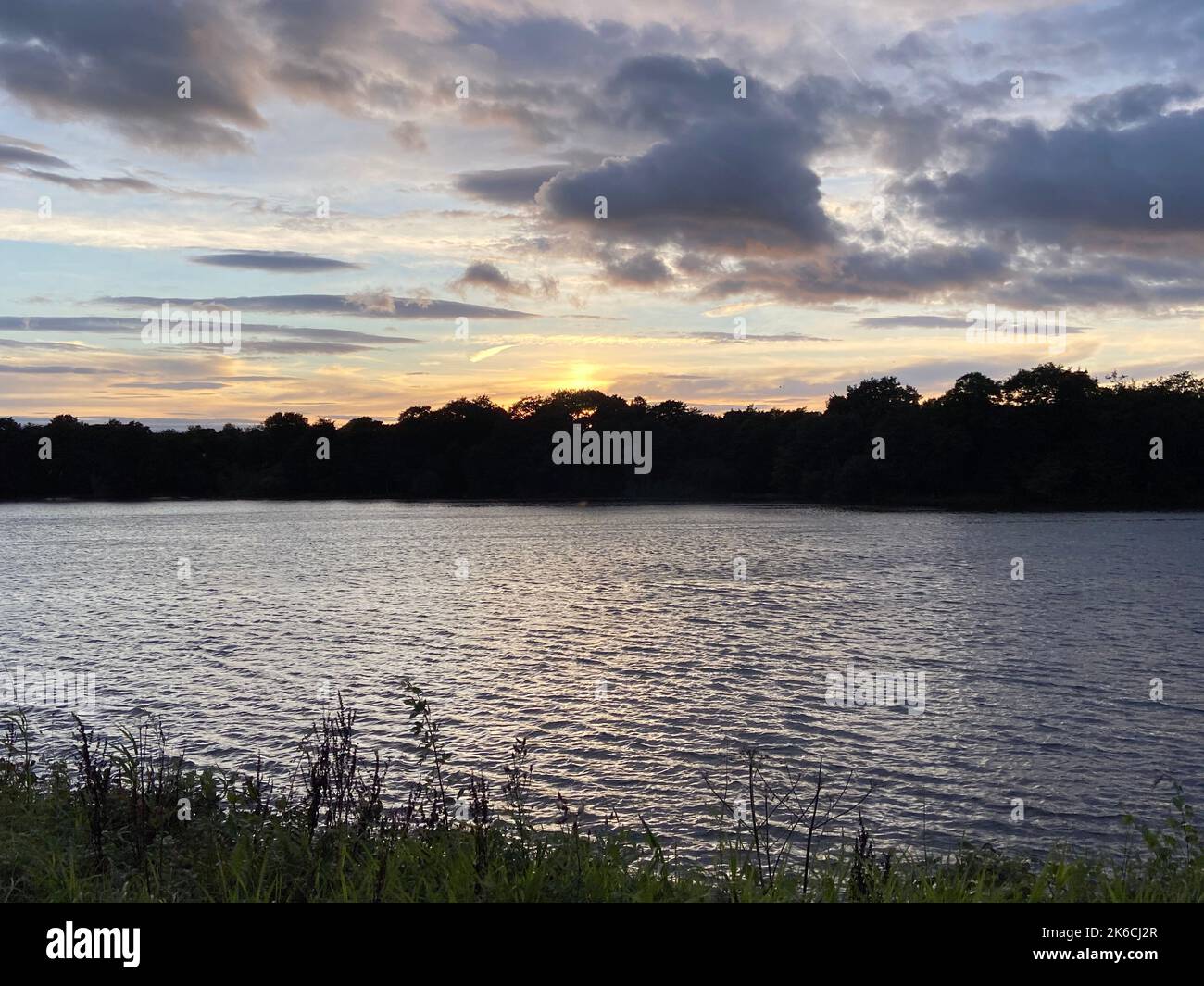 A pond with a wavy water surface under a cloudy sky Stock Photo - Alamy