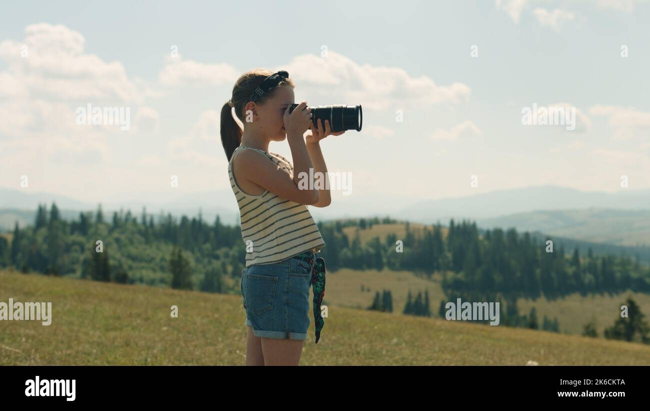 Young photographer shooting landscape on beautifull green hillway ...