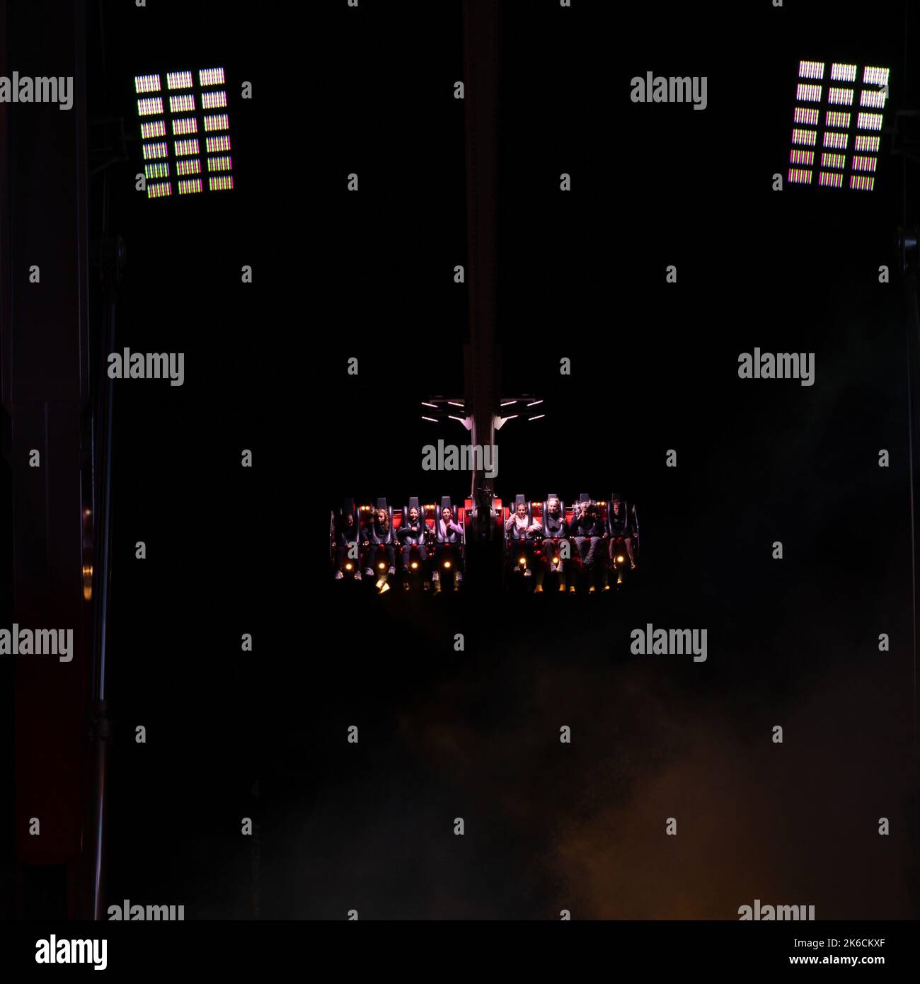 An illuminated attraction with people in the dark at the fair Stock ...