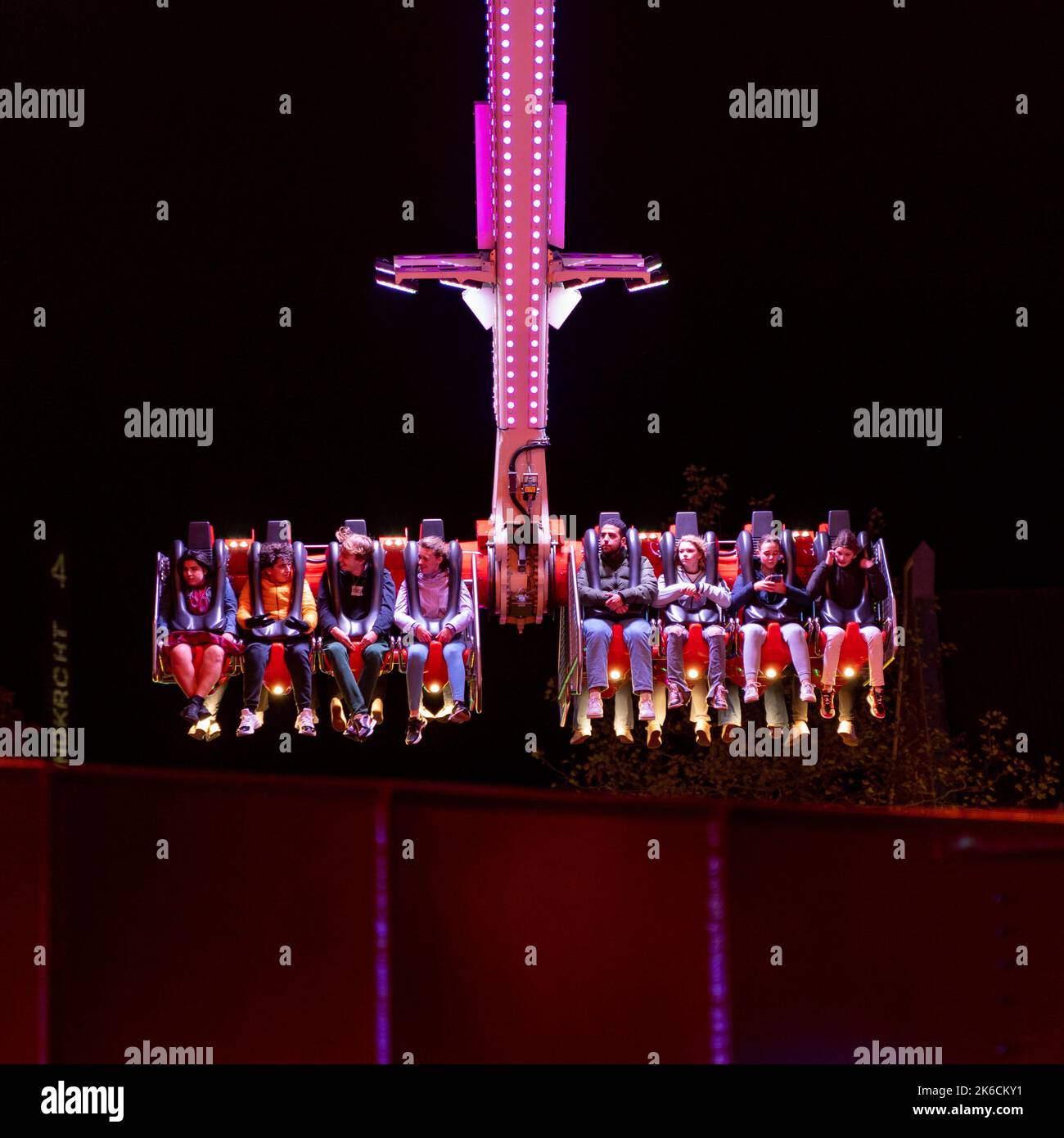 An illuminated attraction with people in the dark at the fair Stock ...