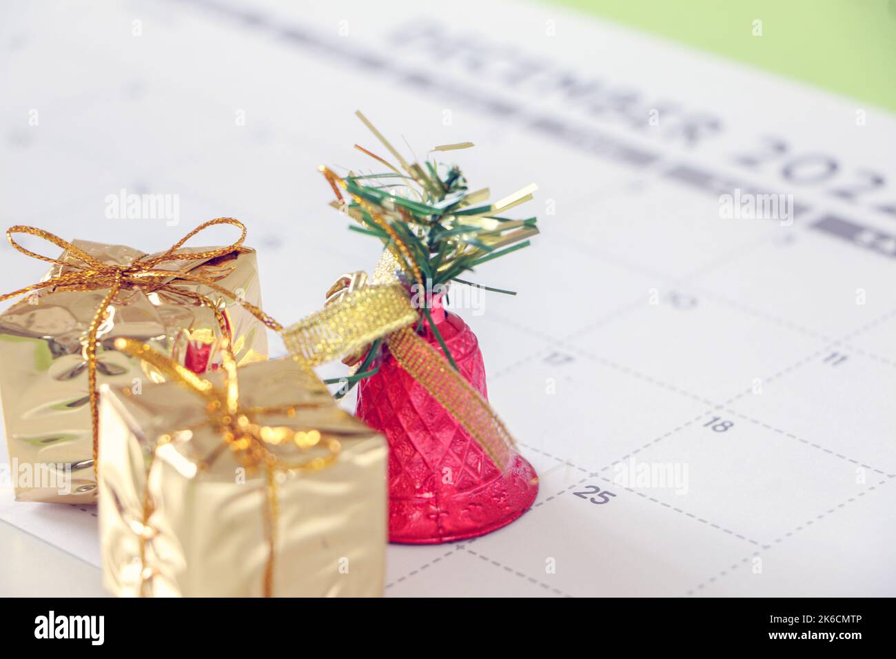 Christmas decor, small gold wrapped gifts and shiny red bell marking ...