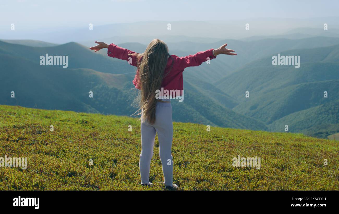 Young girl running on beautiful greenery hill and moves long hair ...