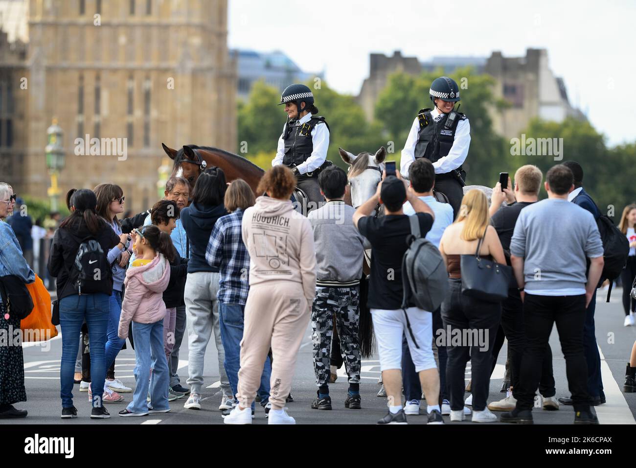 2 metropolitan mounted police officers ride over Westminster Bridge London. On Day 1 Queen lying ...