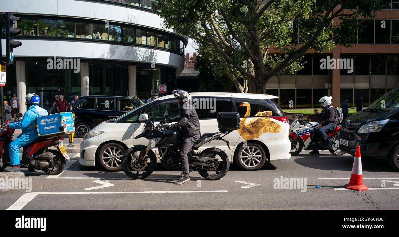 A funny street shot of a motorbike rider looking like he is being ...
