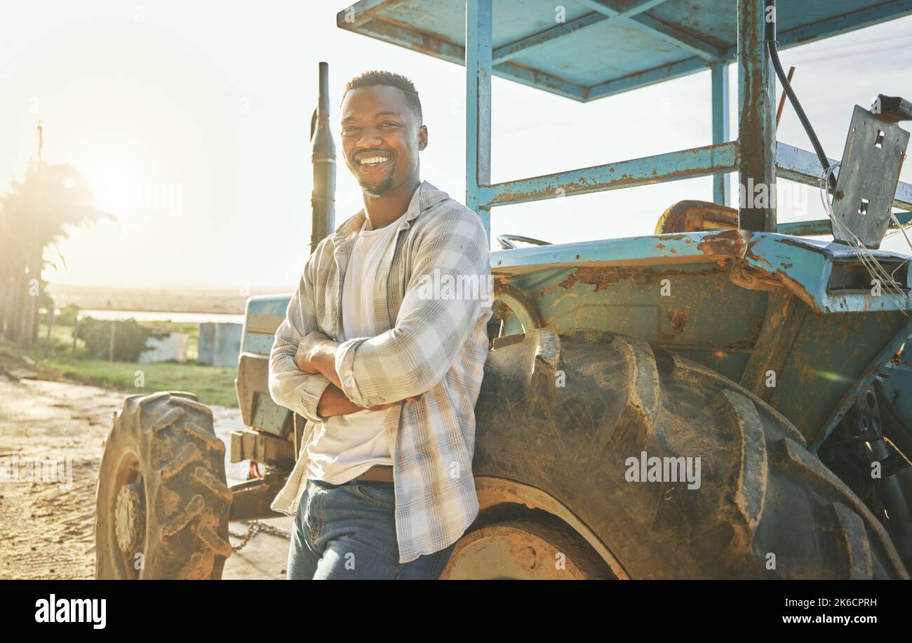 I put in the hard labour. a young farmer standing next to a tractor ...