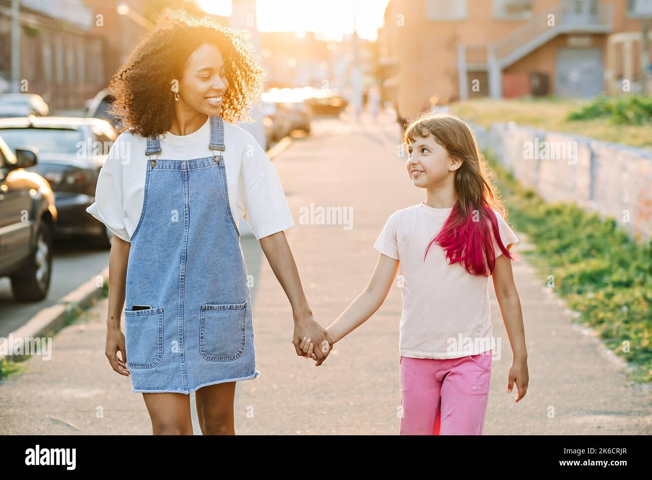 Babysitter young woman and cute school girl having fun and walk ...