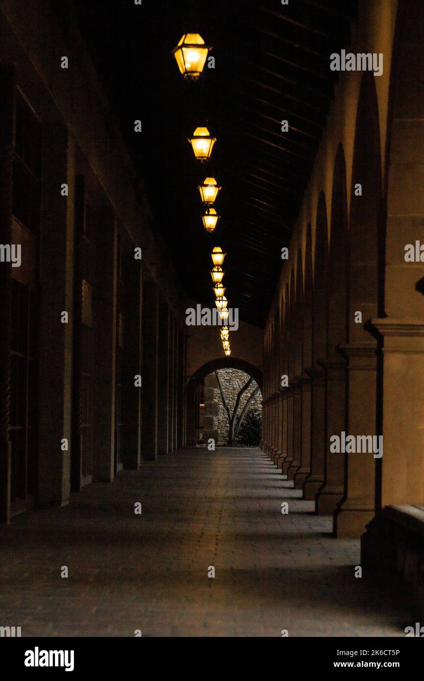 An illuminated pathway under the building Stock Photo - Alamy