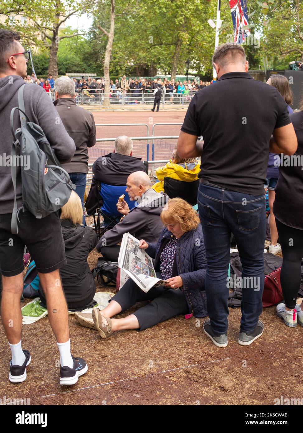 Members of public sit and wait on The Mall after securing their spots ...