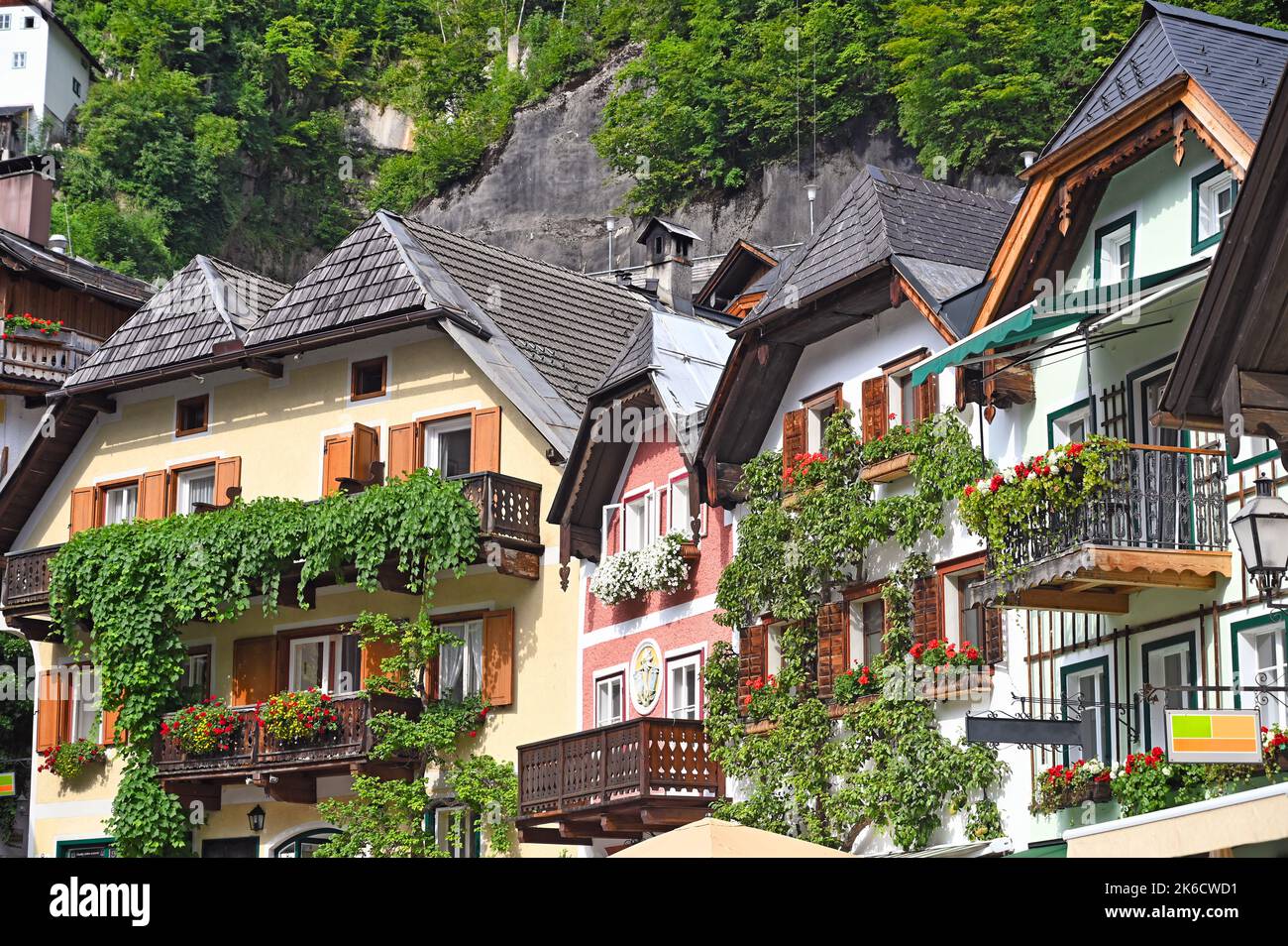 houses with flowers on terraces and windows in Hallstatt village ...
