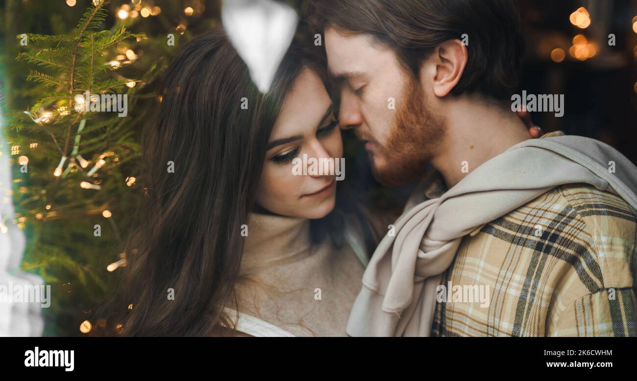 Hugging kissing love couple girl, guy near christmas tree with garland ...
