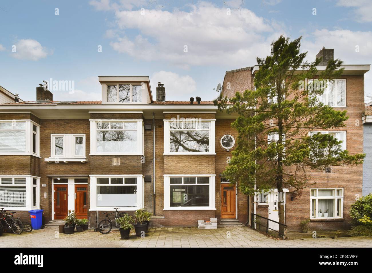 The front view of a brick building with signs, pavement and wooden ...
