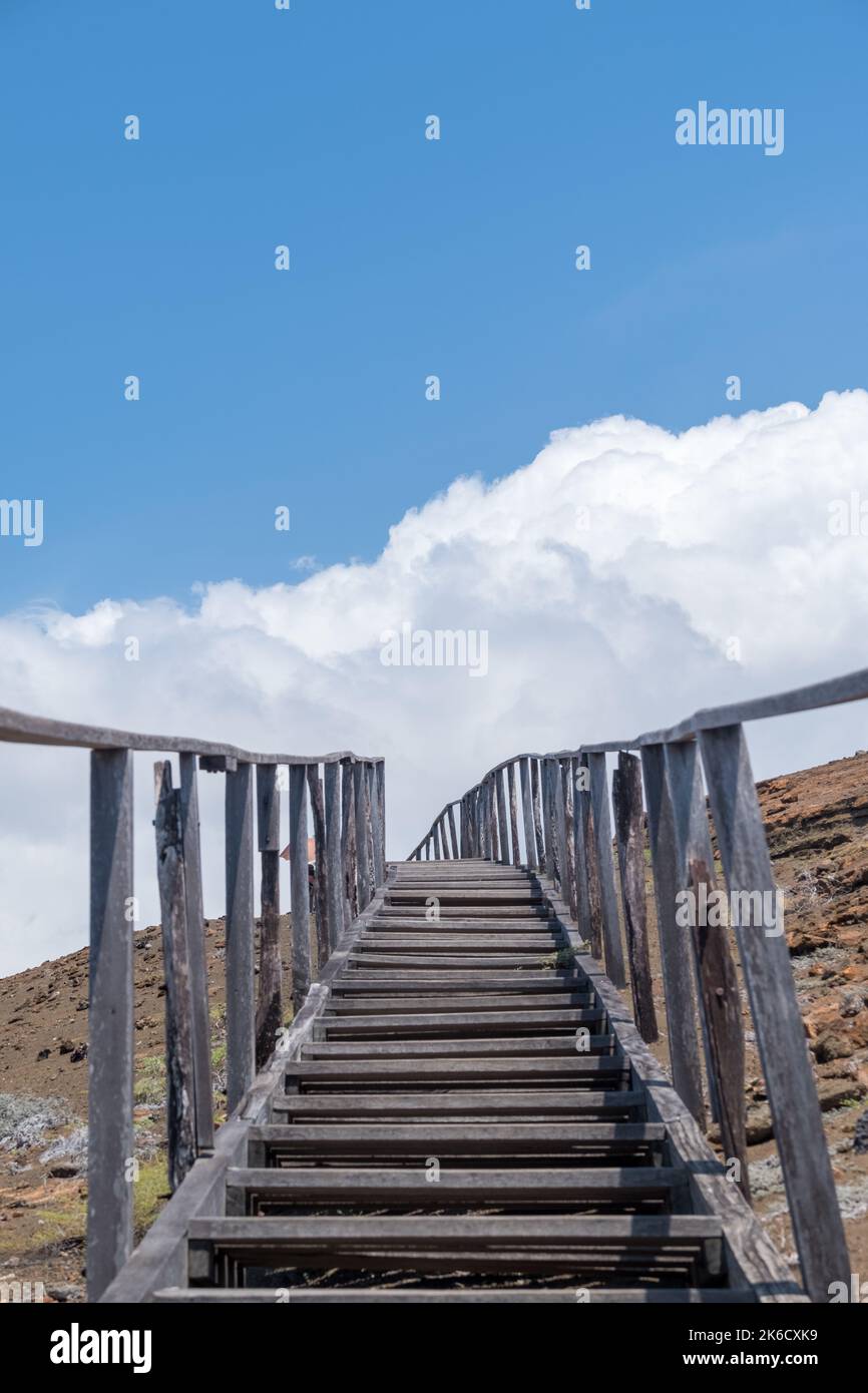 A vertical shot of a staircase leading to the mountains touching the ...
