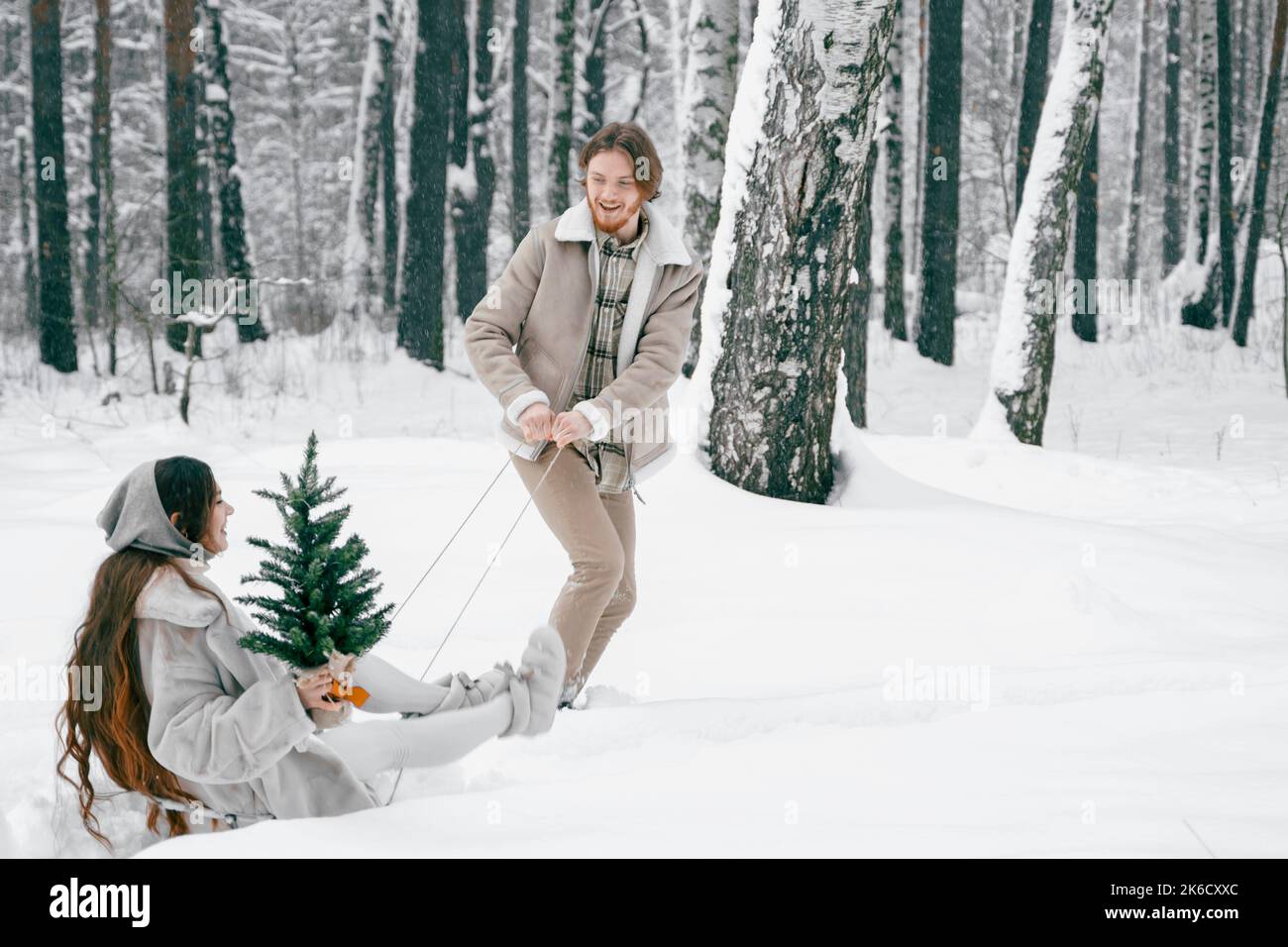 Sledging love romantic young couple girl,guy in snowy winter forest ...