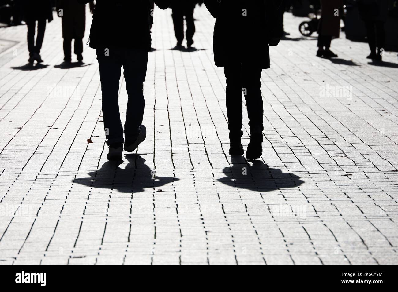 Silhouettes and shadows of people on the street. Crowd walking down on ...