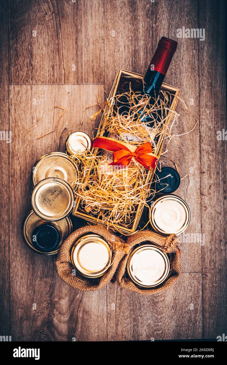 A vertical top view shot of a wine bottle in a wooden box and some jars ...