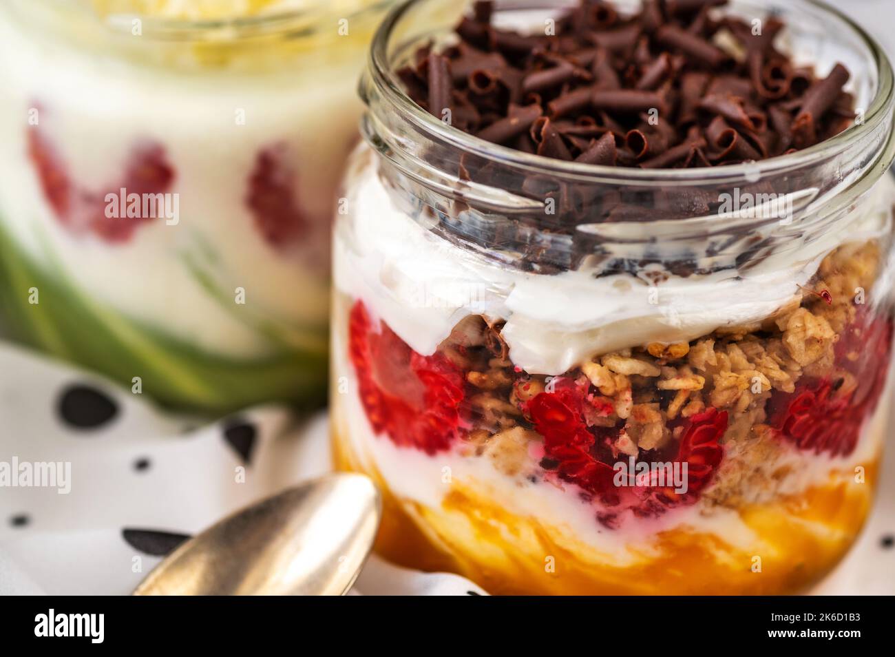 Closeup 2 glass with yogurt, fruit (raspberry, pistachio, mango ...