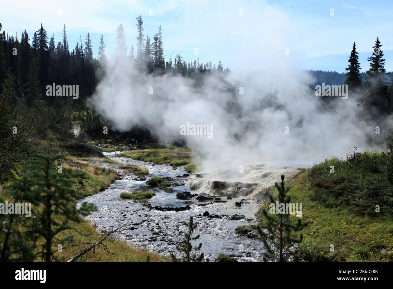 A beautiful shot of a waterfall in a forest with smoke over the ...