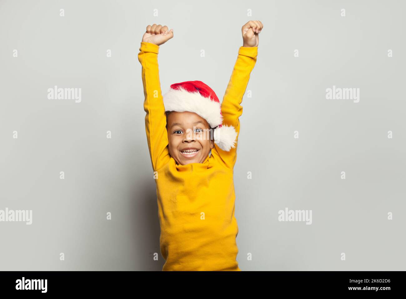 Little black child win-win! Kid boy in Santa hat having fun on white ...