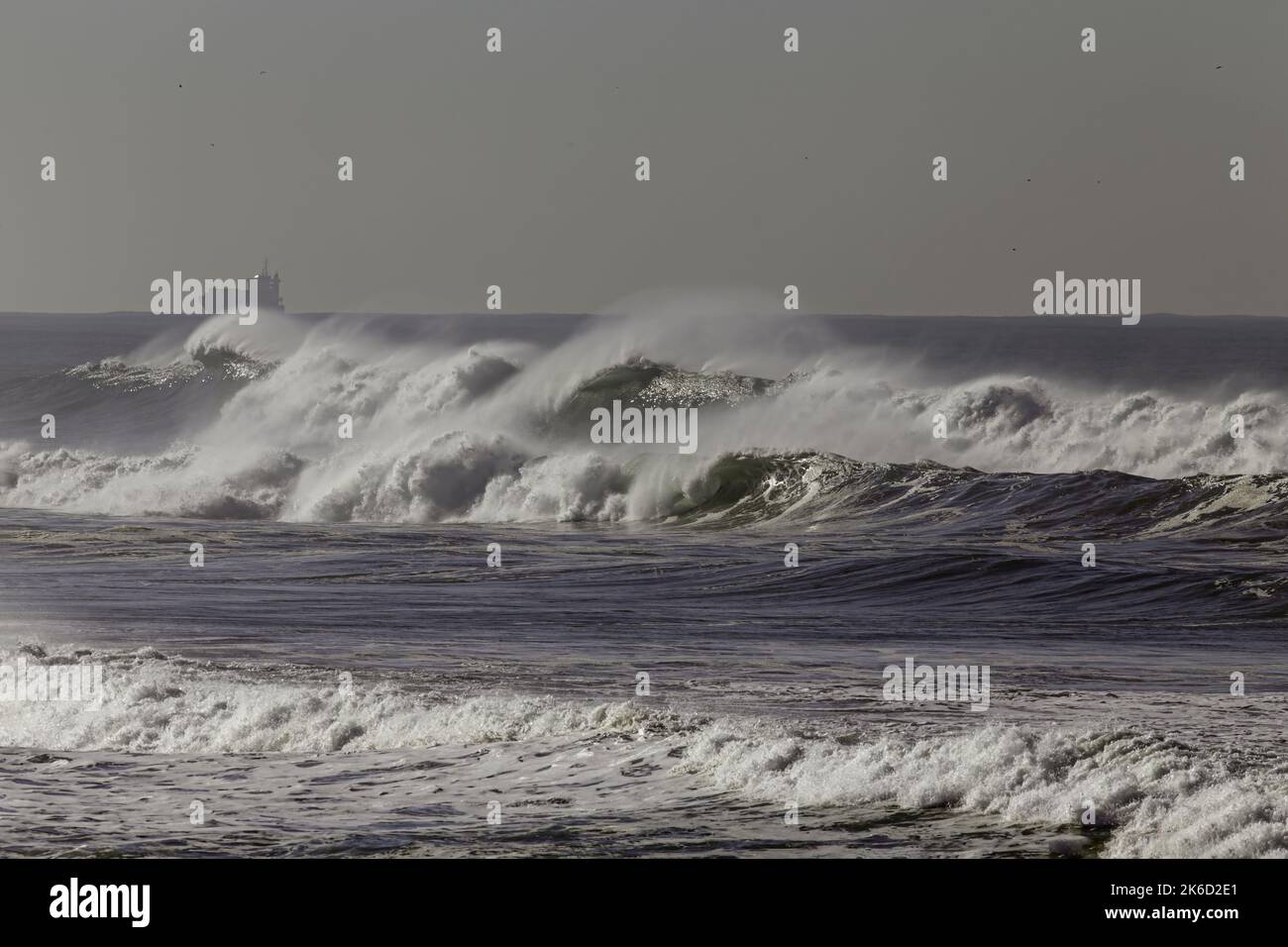 Long stormy wave seeing a ship on the horizon. Northern portuguese ...