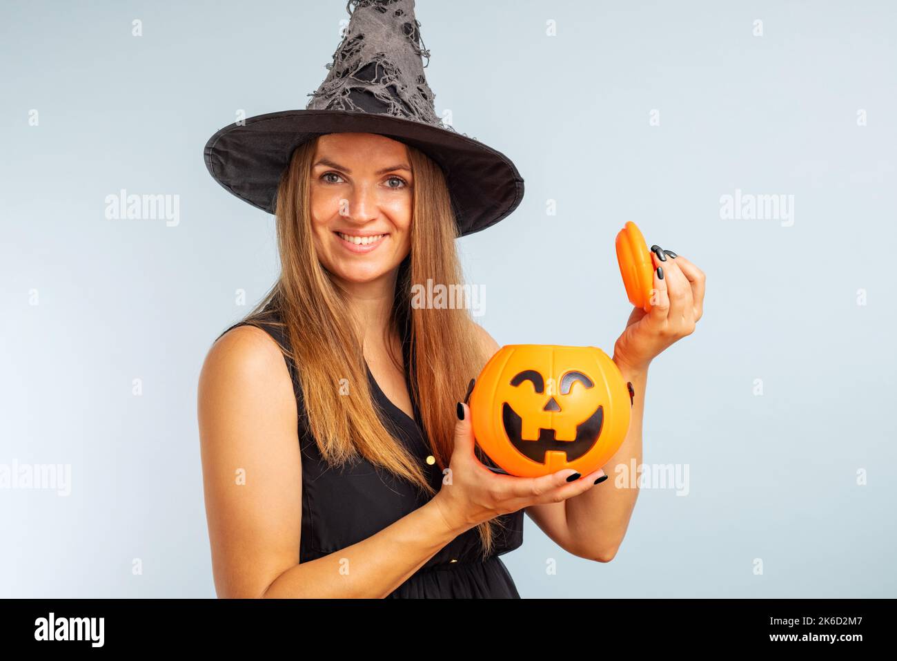 Happy woman in halloween witch costume with pumpkin basket jack-o ...