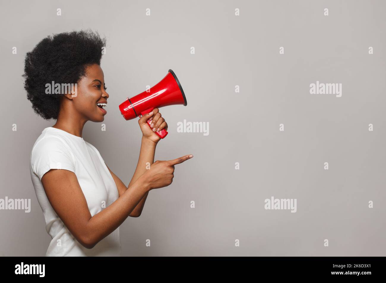 Black model woman with red loudspeaker. Leadership, attention ...