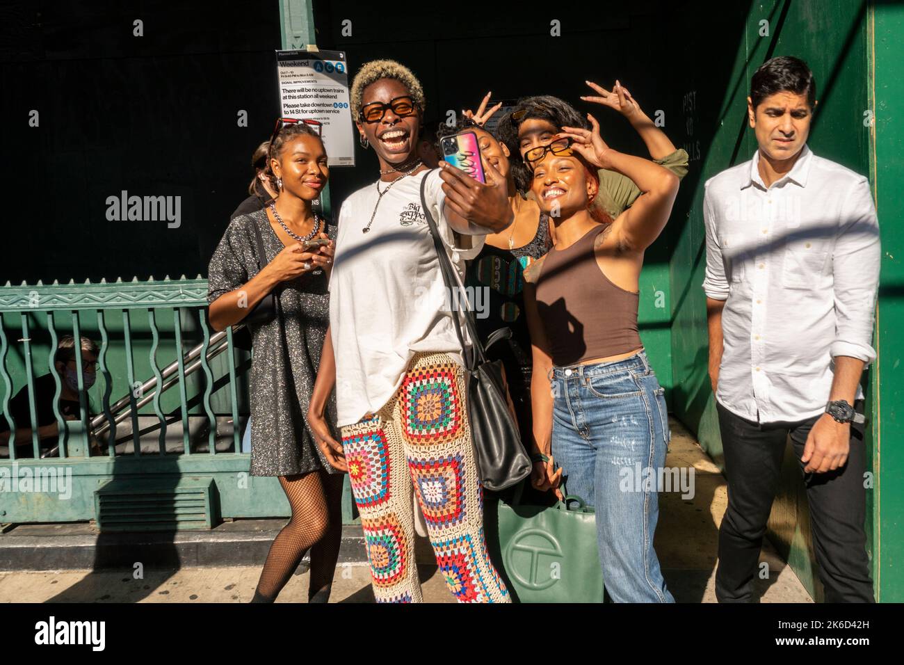 Women exit the subway and immediately pose for a selfie in Chelsea in ...